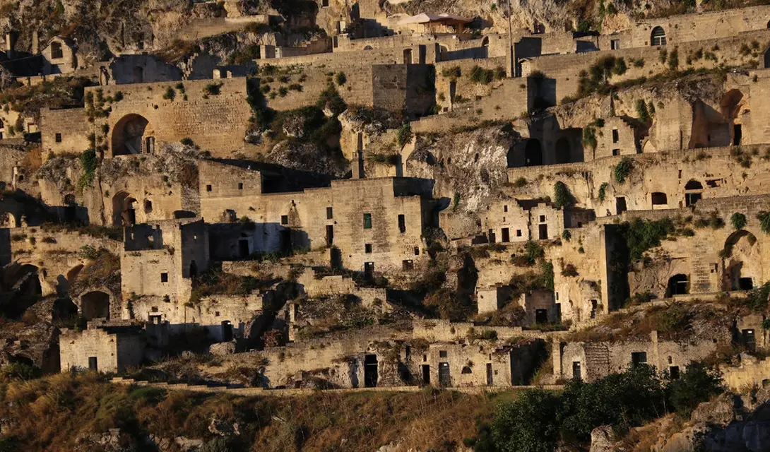 Sassi di Matera Italia Rumah-rumah diukir tepat di gunung, dan penduduk setempat adalah orang pertama yang menetap di Italia. Sampai tahun 1950, gua-gua itu digunakan sebagai perumahan oleh strata penduduk termiskin setempat - pemerintah memukimkan kembali orang-orang ini di lingkungan yang dibuat khusus, dan sebuah monumen wisata didirikan di sini.