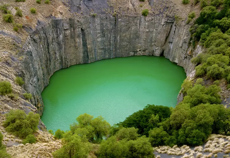 Big Hole, Afurika y'Epfo Quarry yacukuwe hagati ya 1866 na 1914 ikoresheje amatora n'amasuka. Muri kiriya gihe, hacukuwe ibiro 2.722. diyama no gutobora hafi toni miliyoni 22.5 z'ubutaka hejuru. Ubuso bwa kariyeri ni hegitari 17. Uruzitiro rwayo rugera kuri 1,6 km n'ubugari bwarwo ni metero 463. Ku ikubitiro, umwobo wari ufite metero 240 z'uburebure, ariko nyuma wuzuyemo urutare rw'imyanda kugeza ubujyakuzimu bwa metero 215. Kuri ubu, epfo yuzuyemo amazi.