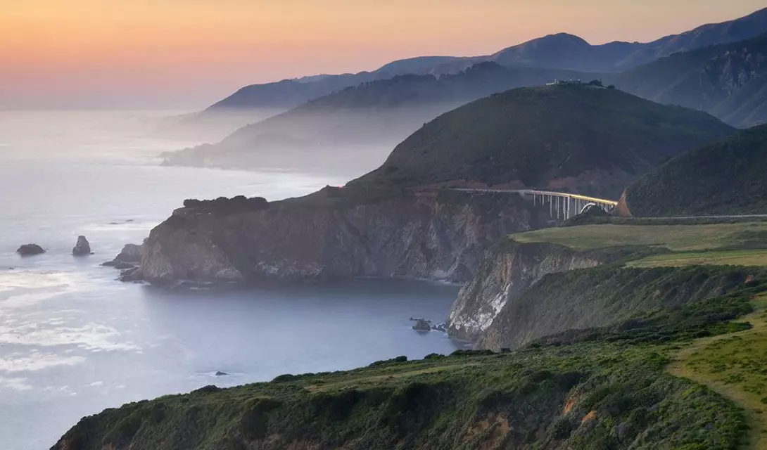 Is fearr a fhéachann Big Sur California ó fhuinneog carr: is féidir le shliocht fada ar cheann de na cóstaí is creagach i California, ag breathnú amach ar an Aigéan Ciúin, dul i bhfeidhm ar an turasóir is mó taithí fiú.