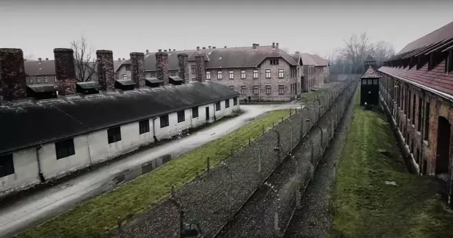 Il-kamera telgħet lejn il-kamp ta 'Auschwitz u ħares lejn il-passat mudlam