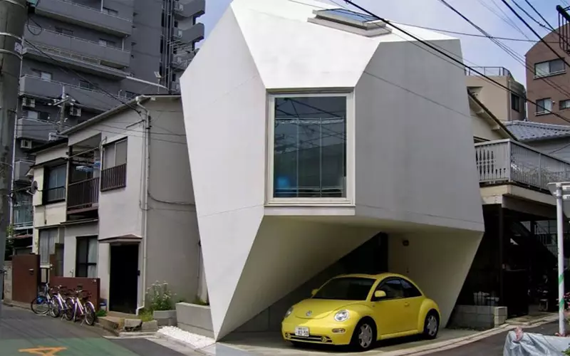 Edge of Tokyo is niet de beste stad voor mensen die op zijn minst een beetje van persoonlijke ruimte houden. De hoge kosten van woonruimte hier hebben ertoe geleid dat hele gezinnen in kleine appartementen moeten kruipen. Architect Yushiro Yamashita heeft een huis gemaakt dat het vierkante probleem oplost. Een competente lay-out en geometrische verdeling van de muren maakten het mogelijk om alles wat u nodig heeft op een minimale oppervlakte te plaatsen, inclusief een carport voor een kleine auto.