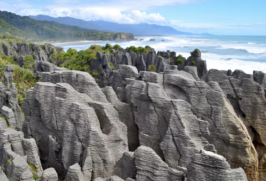 Pancake Rocks, New Zealand Rocks ตั้งอยู่บนชายฝั่งตะวันตกของนิวซีแลนด์ พวกมันก่อตัวขึ้นเมื่อหลายล้านปีก่อน ในช่วงเวลาที่แทนที่จะเป็นพื้นดินกลับกลายเป็นทะเล หลังจากการก่อตัวขึ้นจากส่วนลึกของทะเล ลมและน้ำได้ปรับเปลี่ยนภูมิทัศน์ ทำให้เกิดร่อง ซึ่งต้องขอบคุณก้อนหินที่มีลักษณะคล้ายกองแพนเค้ก