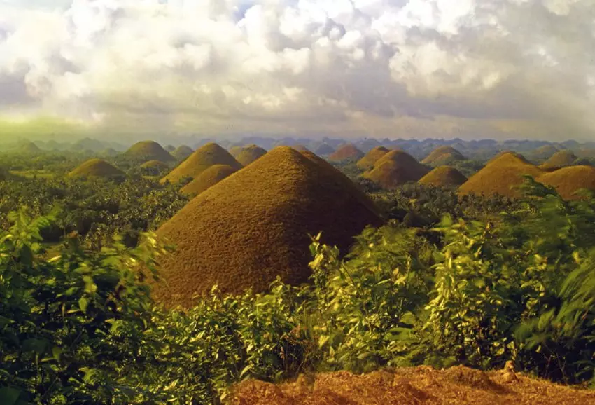 Chocolate Hills ประเทศฟิลิปปินส์ ระดับความสูงเกือบสมมาตรครอบคลุมเกือบ 50 ตารางกิโลเมตร ในจังหวัดโบโฮล จากแหล่งข้อมูลต่างๆ มีเนินเขาตั้งแต่ 1,200 ถึง 1800 เนิน เกือบตลอดทั้งปีจะมีหญ้าปกคลุม แต่ในช่วงฤดูแล้งจะเปลี่ยนเป็นสีน้ำตาล ซึ่งทำให้ภูมิทัศน์ดูแปลกตาไปหมด