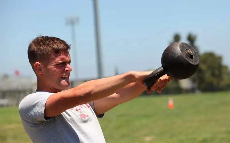 Kettlebell -swaai (swaai) Hierdie oefening versterk die buik- en rompspiere wat gewoonlik nie gestres word tydens ysteroefeninge nie, maar wat belangrik is vir verskillende bewegings, van spring tot sprint. Neem die kettlebell met albei hande, die liggaamsgewig word na die hakke oorgedra, die rug is reguit. Skuif die kettlebell tussen u bene en maak glad, maar vinnig reguit, en bring die kettlebell op die borsvlak.