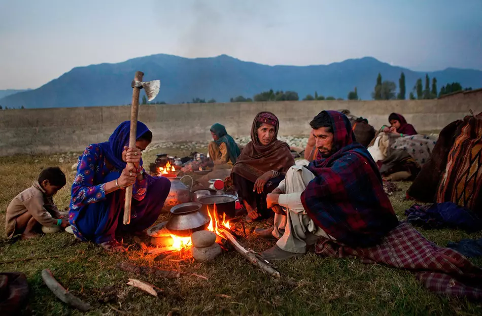 एक परिवार Bakpora को शहर को नजिकै सूर्यास्त मा डिनर तैयार गर्दछ।