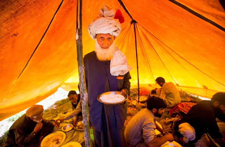 अब्दुल रहिम एक ठूलो पाल भित्र एक विवाह समारोह को दौरान चावल को एक थाली पकड।