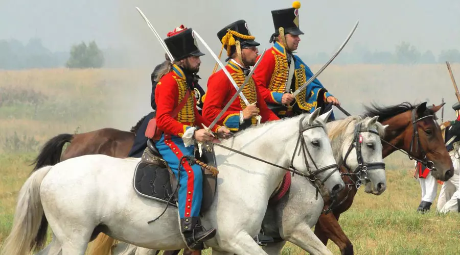 Mentik, shako, dolman Den farverige husaruniform blev lånt fra den polske og ungarske nationaldragt. Doloman var en jakke med en stående krave, broderet med snore. Ovenfor kastede de også en dekoreret mentik, der blev båret i ærmerne om vinteren, og betjentens krave var pyntet med pels. I dårligt vejr blev der også brugt en kludkappe. Hovedbeklædningen var en høj shako. Tourniquets og fletninger prydede ikke kun uniformen - de adskilte officerernes rækker. På benene bar de smalle chakchirs, det vil sige leggings, med kanter og snore og lave ankelstøvler. Tashka - en flad lommepose - blev båret over højre skulder og hængt ved knæet. Bortset fra de ændringer, der i nogen tid blev foretaget af militæruniformen af ​​Alexander III, bevarede husaruniformen sit generelle udseende indtil 1917.