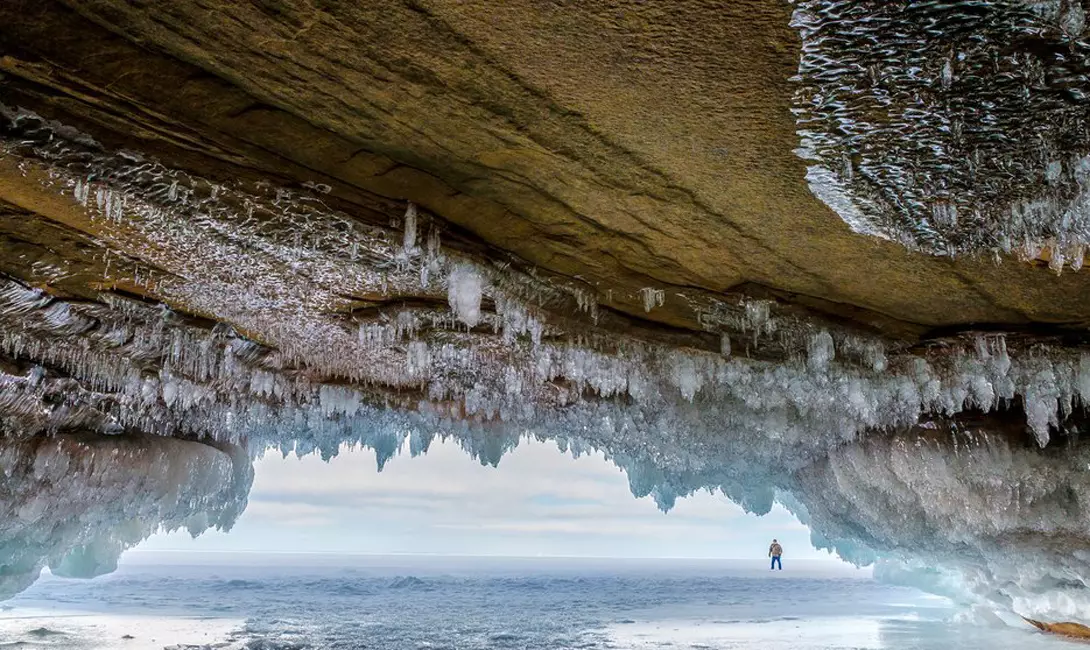 Danau Luhur Wisconsin, AS Nalika suhu turun sareng cai Danau Luhur ditutupan ku és, guha keusik di bojong Pulau Rasul ngajantenkeun pamandangan anu nyata pikeun dongéng. Curug leutik beku dina cascades of dodecahedrons cemerlang, sareng wisatawan tiasa dugi ka dieu kantun leumpang ngalangkungan danau.