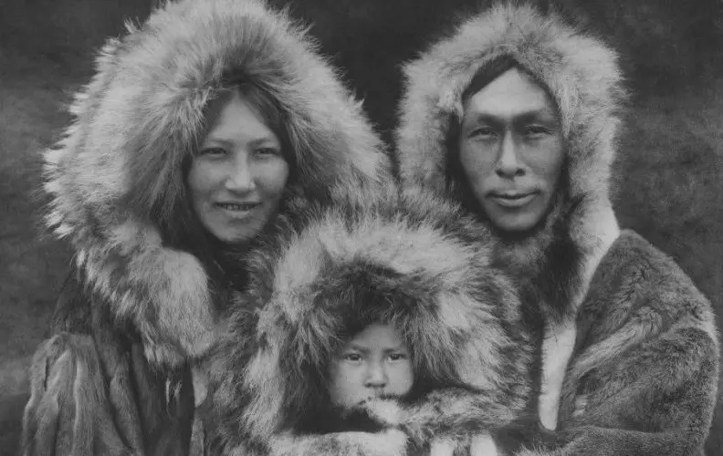 La tenue traditionnelle des Esquimaux du Canada se compose de deux costumes de fourrure portés l'un sur l'autre. Les peaux de la combinaison supérieure sont tournées avec la fourrure vers l'extérieur et celle du bas - avec la fourrure vers l'intérieur. Chaque combinaison se compose d'une parka avec une capuche, d'un pantalon, de gants et de bottes. Ainsi, la double couche de fourrure protège parfaitement tout le corps du froid. Les Esquimaux ne portent pas de ceintures, donc les deux parkas pendent librement pour la ventilation. Pour la fabrication des bottes, on utilise une peau de cerf, qui est cousue avec de la fourrure à l'extérieur afin que le pied ne glisse pas sur la glace. Les vêtements en peau de renne offrent non seulement une excellente isolation thermique. Il peut également devenir le seul moyen d'évasion dans le cas où un chasseur tomberait accidentellement à travers la glace. Le poil d'un cerf étant creux, cela permet à une personne de rester longtemps à la surface, parfois jusqu'à plusieurs heures, ce qui augmente considérablement les chances de salut.