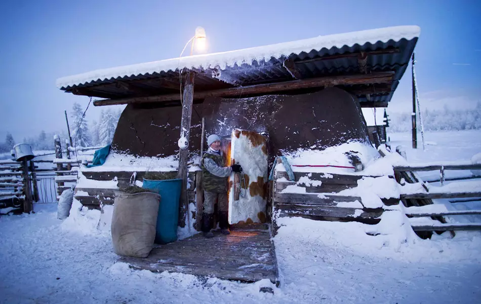 Boer Nikolai Petrovich sluit de deur in een verwarmde stal nadat hij zijn koeien daar 's nachts heeft gereden.