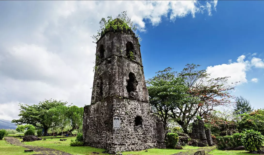 Fransisken manastırının ayakta kalan tek kulesi, Mayon Dağı'nın doğal güzelliğini bir şekilde ortaya koyuyor. Efsaneye göre, diğer tüm binalar yanardağın patlaması sırasında yok edildi, ancak araştırmacılar bu gerçeği tartışmalı buluyor.