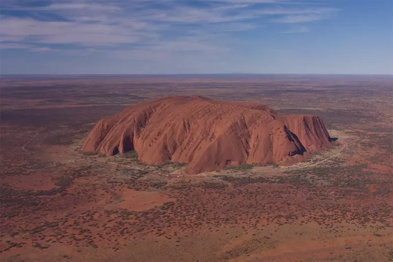 Uluru, Austraalje In massale ovaalfoarmige oranje-brune rots foarme sawat 680 miljoen jier lyn. It leit yn 'e midden fan' e woastyn. De monolit is 3,6 km lang, sawat 3 km breed, en de berch rint 348 meter op. Oan 'e basis fan' e berch binne grotten wêryn âlde tekeningen binne bewarre bleaun.