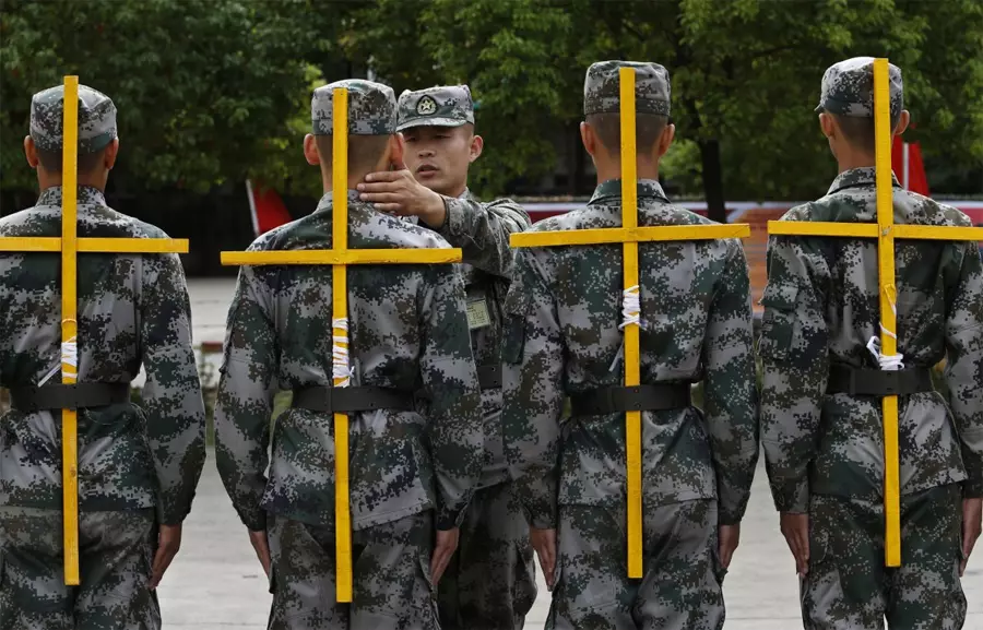 Marchering med et kors på ryggen Sted: Hangzhou, Kina År: 2013 At marchere med et kors fastspændt på ryggen er en del af den kinesiske befrielseshærs marcherende aktiviteter. Ifølge de kinesiske instruktører udvikler hun ikke kun den korrekte holdning til soldaterne, men disciplinerer dem også.