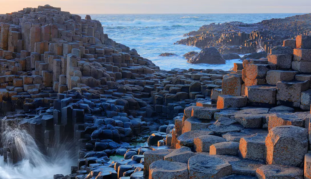 Giant's Causeway Irlandia Północna Wyjątkowy obszar z ponad 40 000 bazaltowych kolumn. Połączyli się ze sobą w wyniku erupcji wulkanu, a starożytne plemiona wymyśliły już legendę, że trolle pójdą do Ragnarok wzdłuż tych filarów.