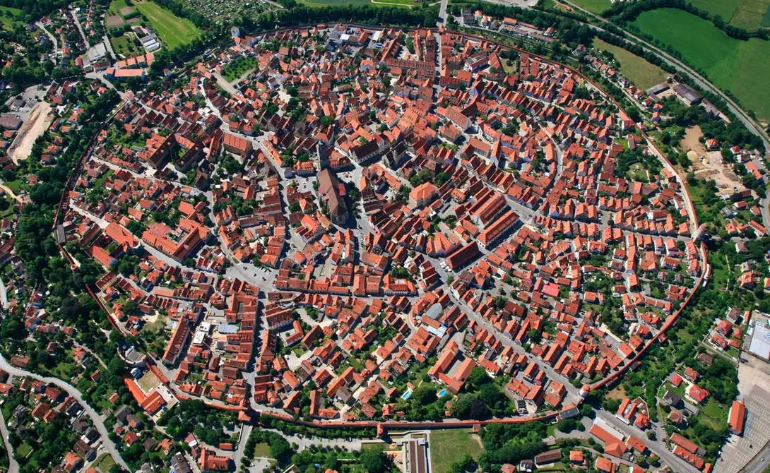 Nordlingen Germany Thành phố này chỉ mới khoảng một nghìn năm tuổi, nhưng miệng núi lửa nơi nó được thành lập đã xuất hiện cách đây 15 triệu năm. Thiên thạch để lại một thung lũng lý tưởng, được bảo vệ hoàn hảo từ mọi phía bởi các rào cản tự nhiên. Người dân địa phương rất coi trọng lịch sử của họ - vẫn còn, hài cốt của kẻ lang thang không gian vẫn nằm rải rác trong khu vườn của họ.