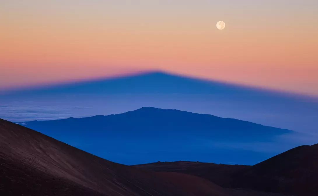 Parallel Mountains Shadow Manua Kea, der höchste Gipfel Hawaiis, wird von der Sonne verdoppelt, die über dem Vulkan aufgeht.