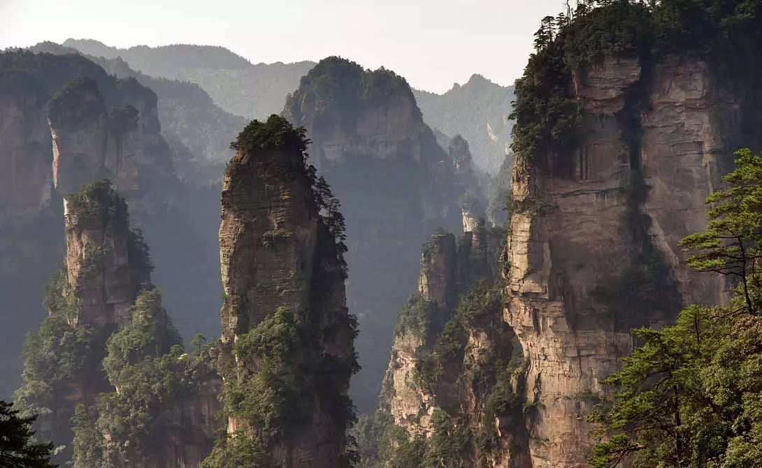 Zhangjiajie National Forest Park China Gelegen in het zuidelijke deel van de Chinese provincie Hunan, is Zhangjiajie National Forest Park een surrealistische ruimte van stenen torens waardoor bomen in verschillende richtingen groeien.