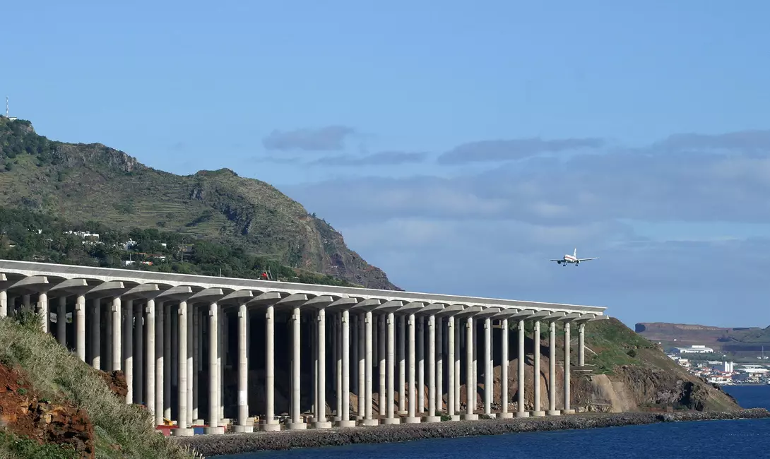 Aeroporto de Madeira Funchal Orixinalmente, o aeroporto de Madeira tiña dúas pistas, cada unha cunha lonxitude de 1600 metros. Pero despois dun accidente aéreo en 1977, que causou a morte de 131 pasaxeiros, os enxeñeiros finalmente déronse conta de que esa lonxitude non era suficiente para as manobras e alargaron as pistas en 200 metros. Tal transformación non mellorou moito as condicións para o despegue e o pouso e no 2000 decidiuse completar a pista, colocando parte dela sobre 180 apoios de formigón armado. O deseño inusual compleméntase cunha paisaxe variada: por un lado do aeroporto hai o mar, por outro - montañas, o que require unha certa habilidade dos pilotos para realizar manobras.