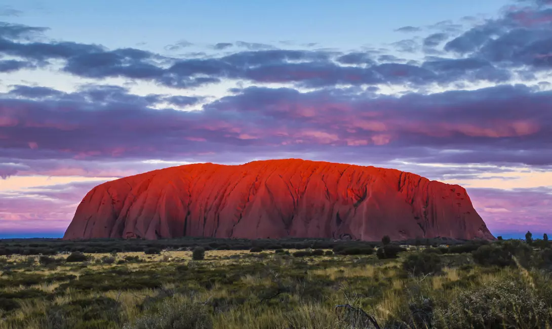 Ang Uluru Australia Mountain range ay nagbabago ng kulay nito depende sa taas ng araw. Inirerekumenda namin na gugulin mo hindi lamang ang gabi, ngunit ang buong araw na nanonood ng mga mahiwagang pagbabagong ito.