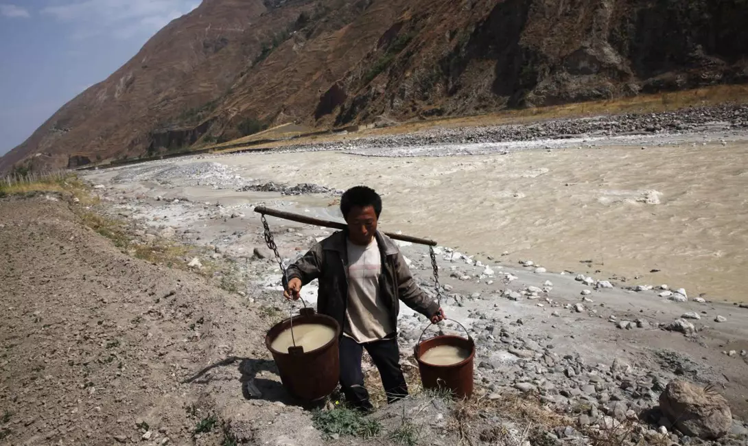 O se tagata o le nuʻu na te aveina pakete vai inu mai se vaitafe eleelea. Saina, Yunnan itumalo.