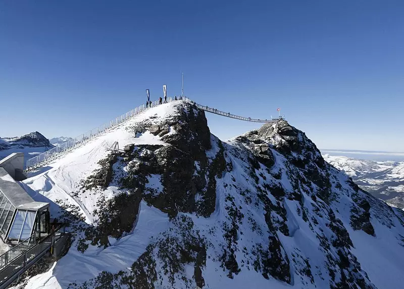 Peak Walk, Schweiz Die Brücke verbindet die Gipfel von zwei Dreitausendern - dem Scex Rouge Peak und dem Glacier 3000. Die Brücke ist 107 Meter lang und nur 80 cm breit. Die Brücke führt zu einer Aussichtsplattform, von der aus Sie die Aussicht genießen können der Gipfel Matterhorn, Jungfrau, Eiger und Mönch.