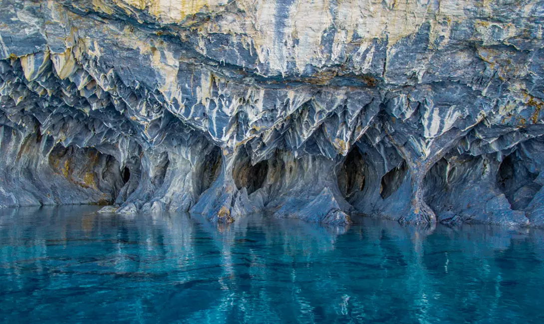 Mapiri a Marble aku Chile Tawuni ya Cuevas de Marmol ili ndi zaka sikisi sikisi. Phanga lokongola ili ndi mkatikati mwa chombo mumakhala nyanja m'malo pansi, yomwe imakongoletsa makoma ake ndi zojambula zodabwitsa.